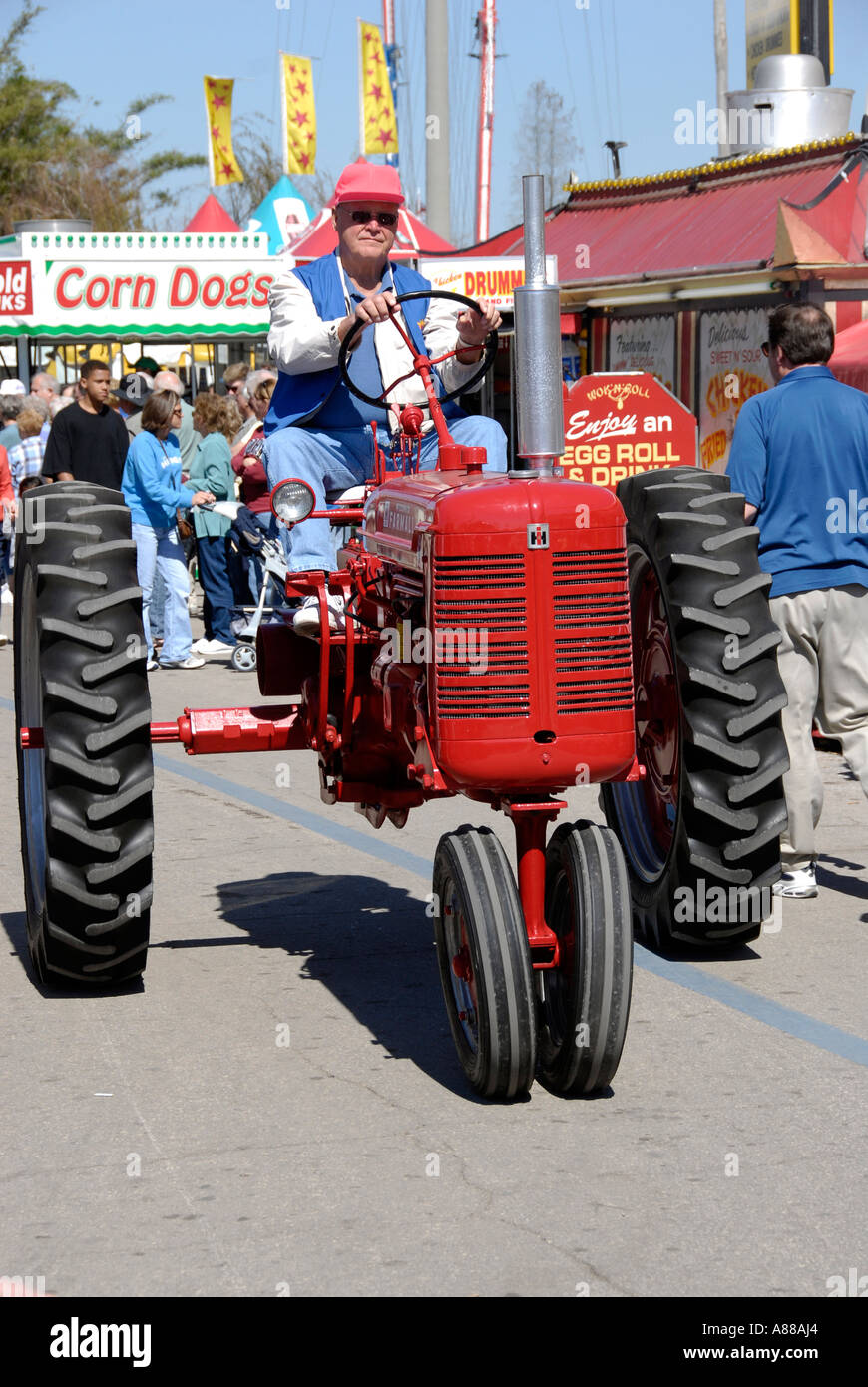 Farmers driving and riding tractors participate in a parade at the ...