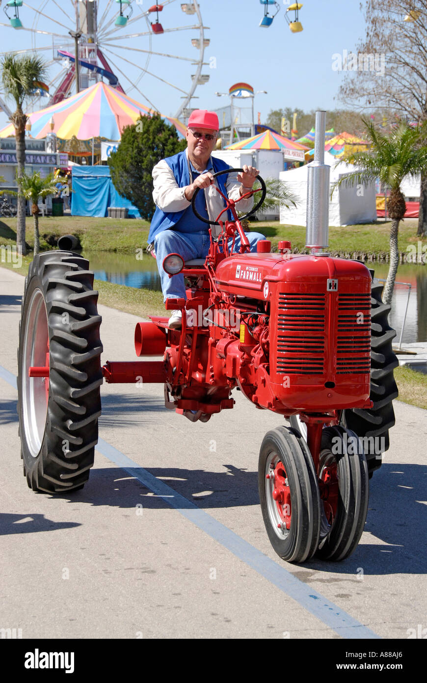 Farmers driving and riding tractors participate in a parade at the ...