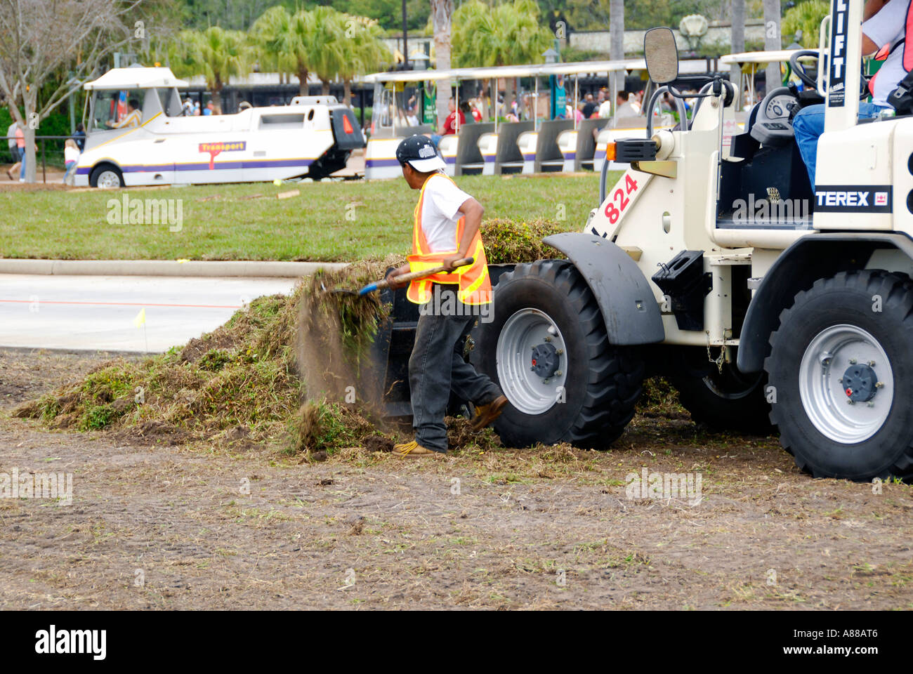 Construction workers clean up and prepare landscape prior to laying new ...