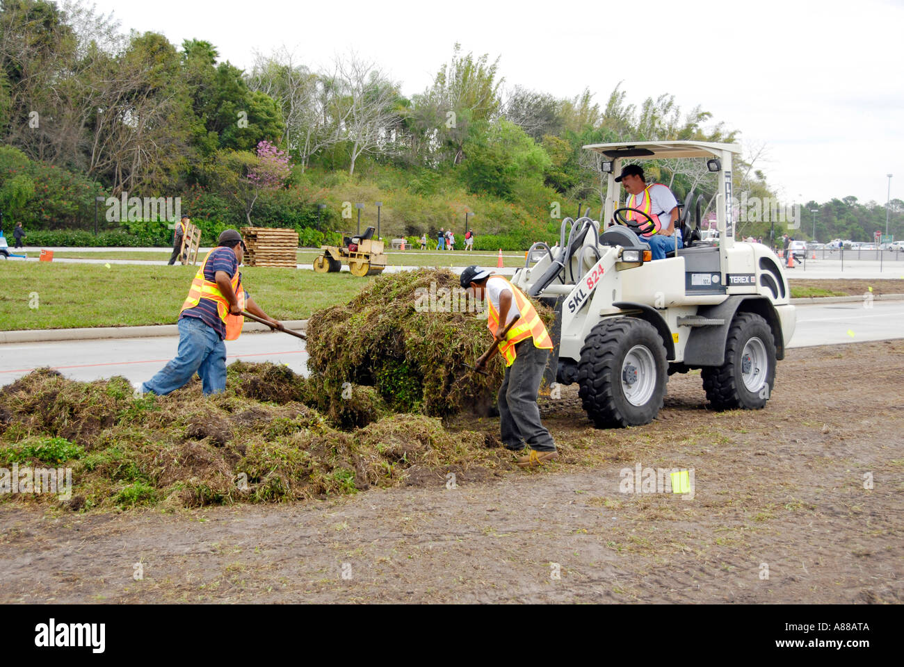 Construction workers clean up and prepare landscape prior to laying new ...