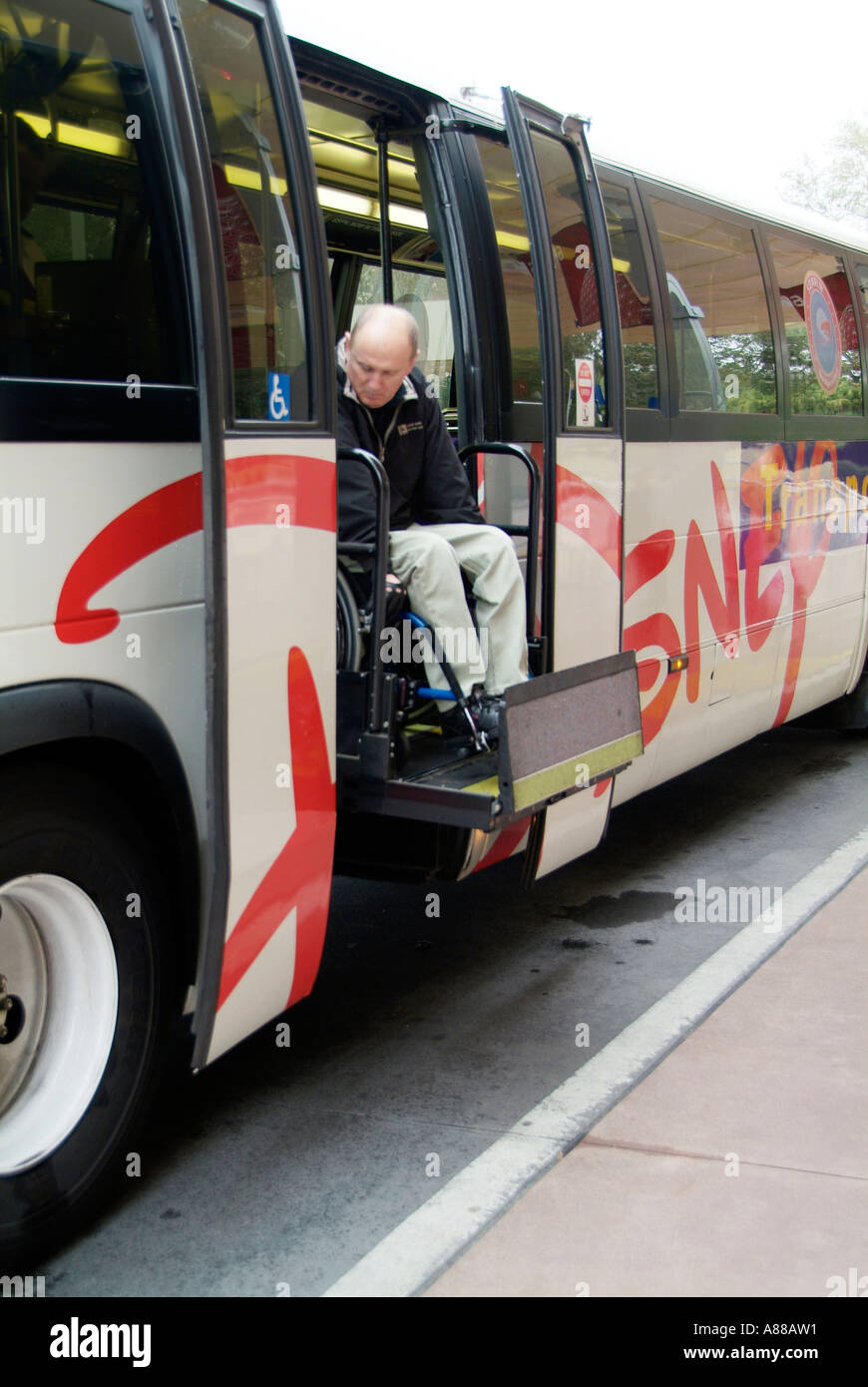 Man departs a public transportation bus by way of handicapped elevator ...