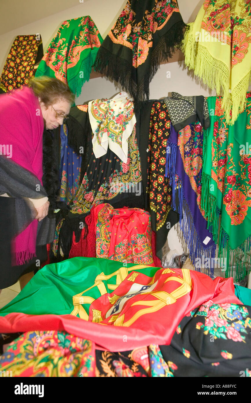 an old women selling traditional portuguese fabrics in a store in ...
