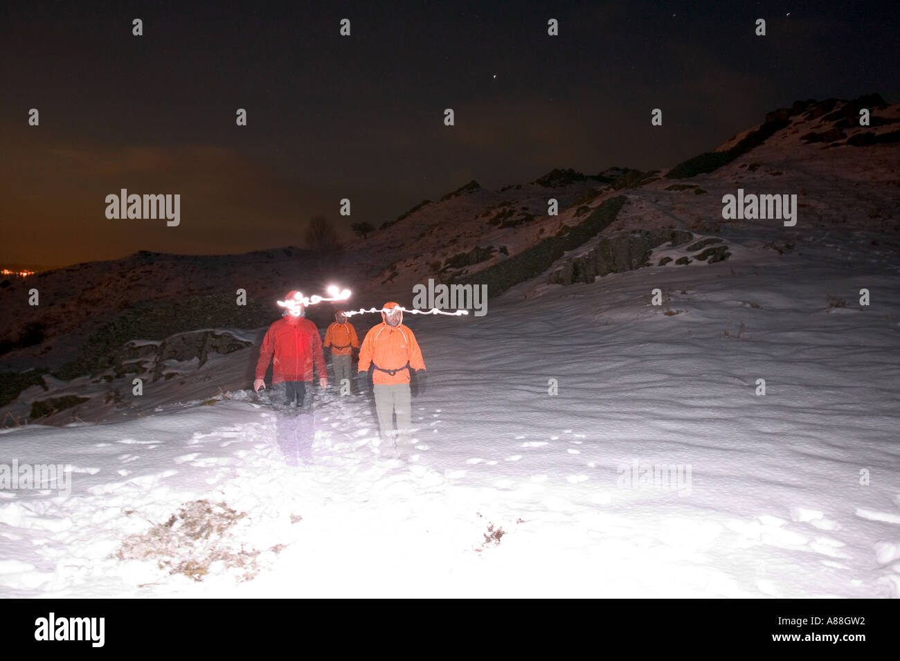 Full moon over Ambleside in winter snow with climbers ascending by ...
