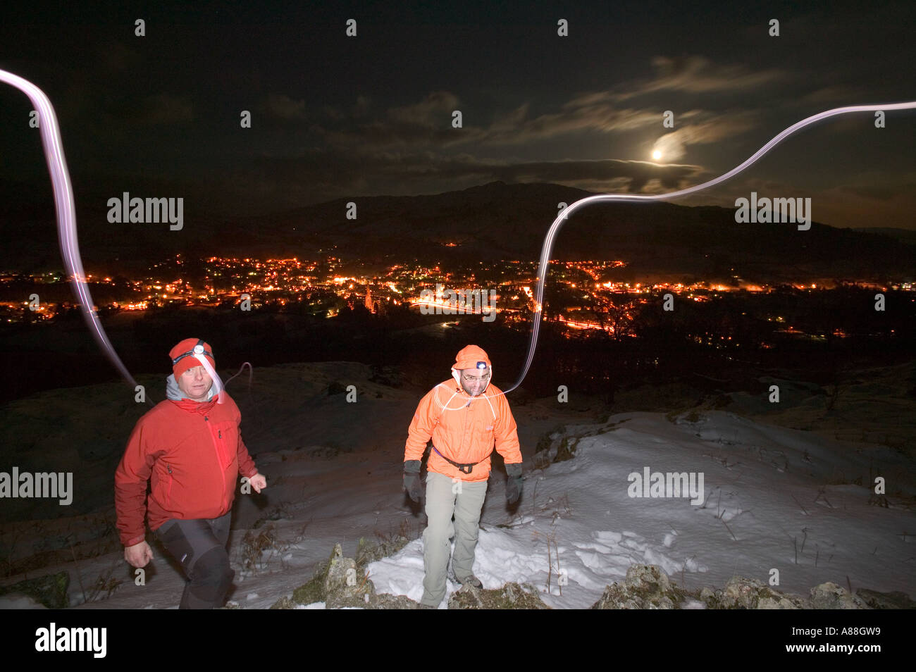 Full moon over Ambleside in winter snow with climbers ascending by ...
