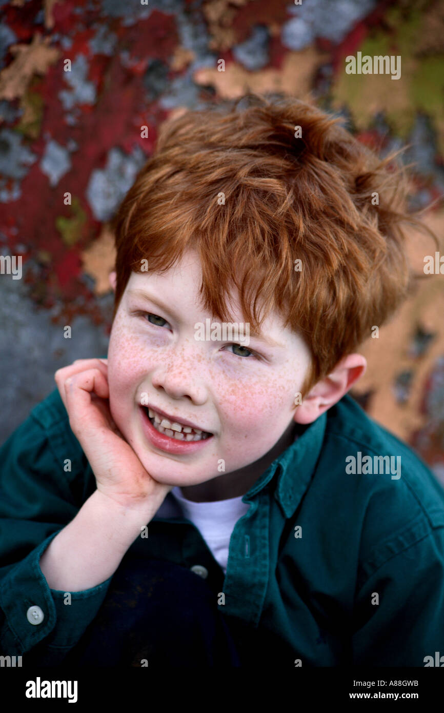 Vertical close up profile portrait of young red haired boy with chin on ...
