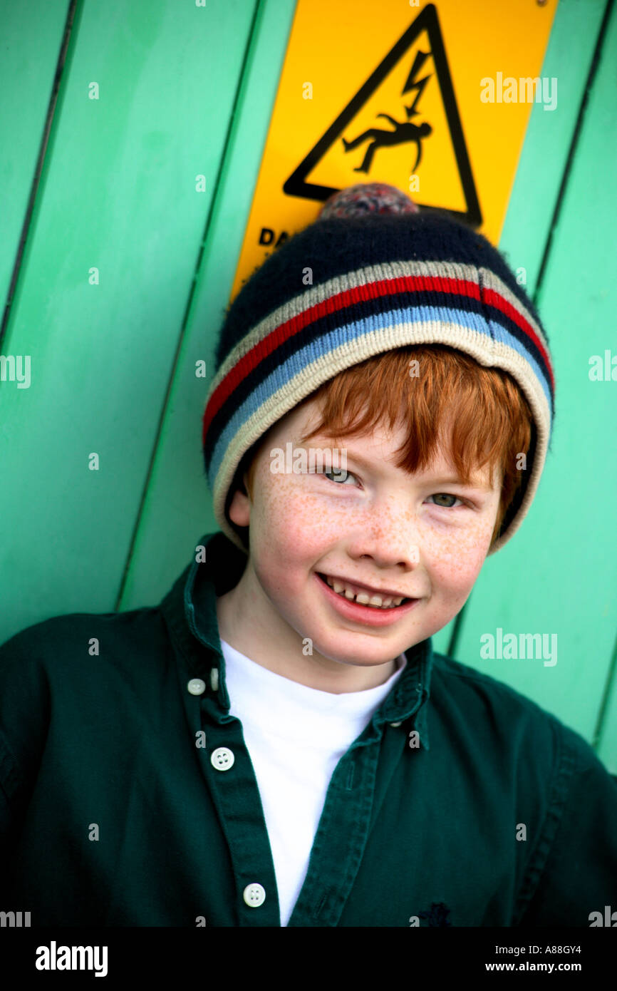 Vertical close up bright coloured portrait of ginger haired little boy ...