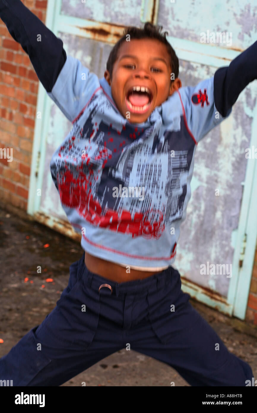 Vertical portrait of young afro caribbean boy jumping in the air in ...