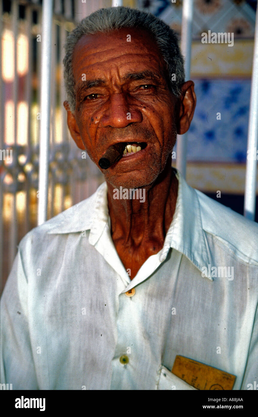 portrait of an old afro Cuban elderly man smoking a cigar in Trinidad ...