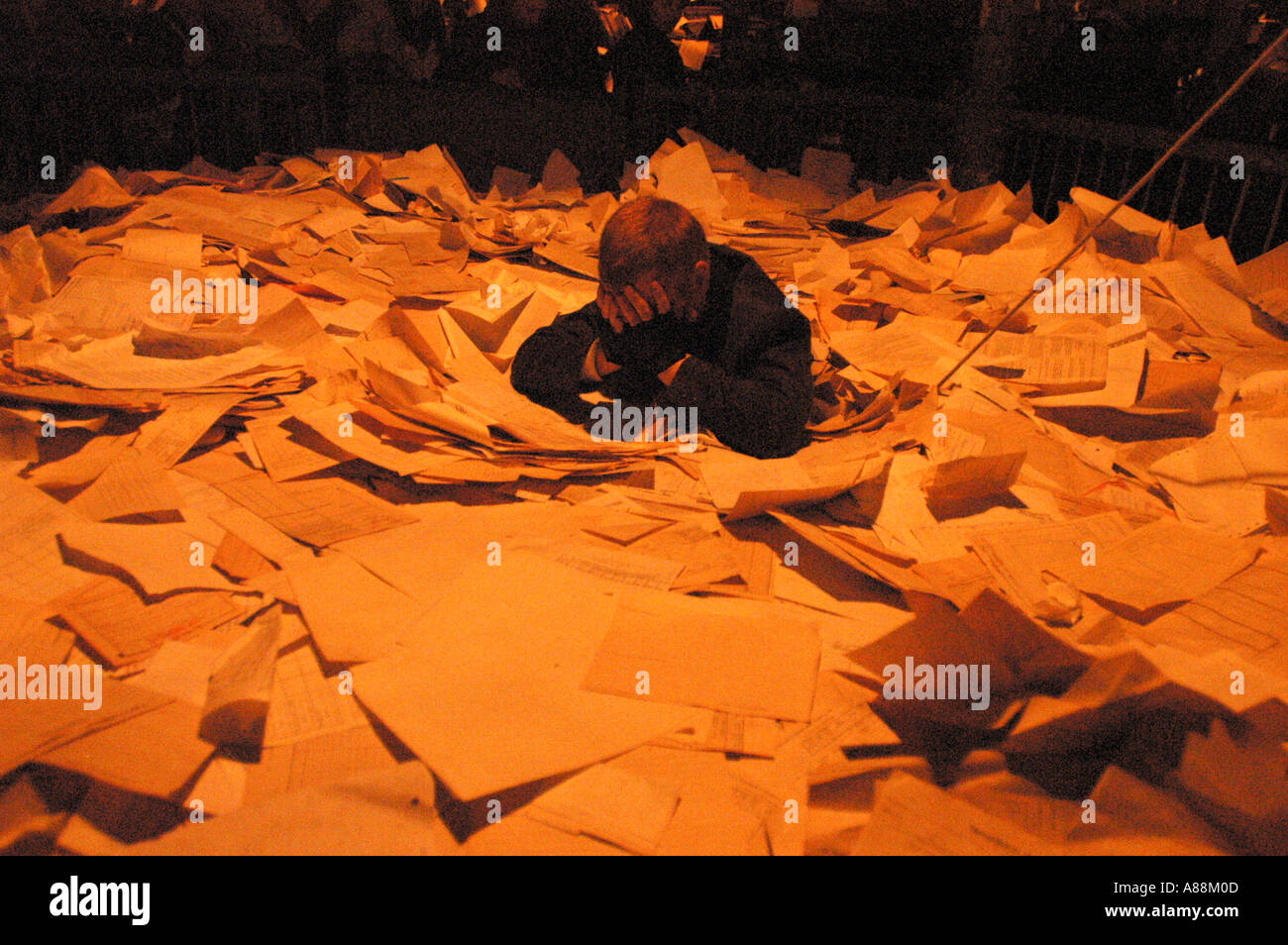 A man inside pool full of papers crying Stock Photo - Alamy