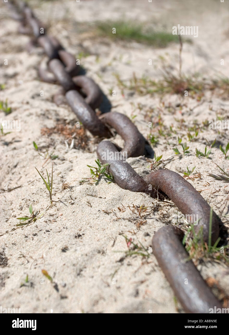 Half buried iron chain on sand Stock Photo - Alamy