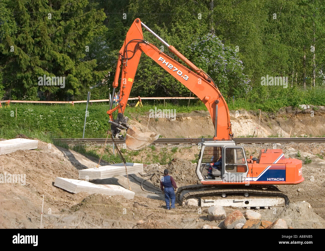 Digger lifting a concrete slab at construction site , Finland Stock ...