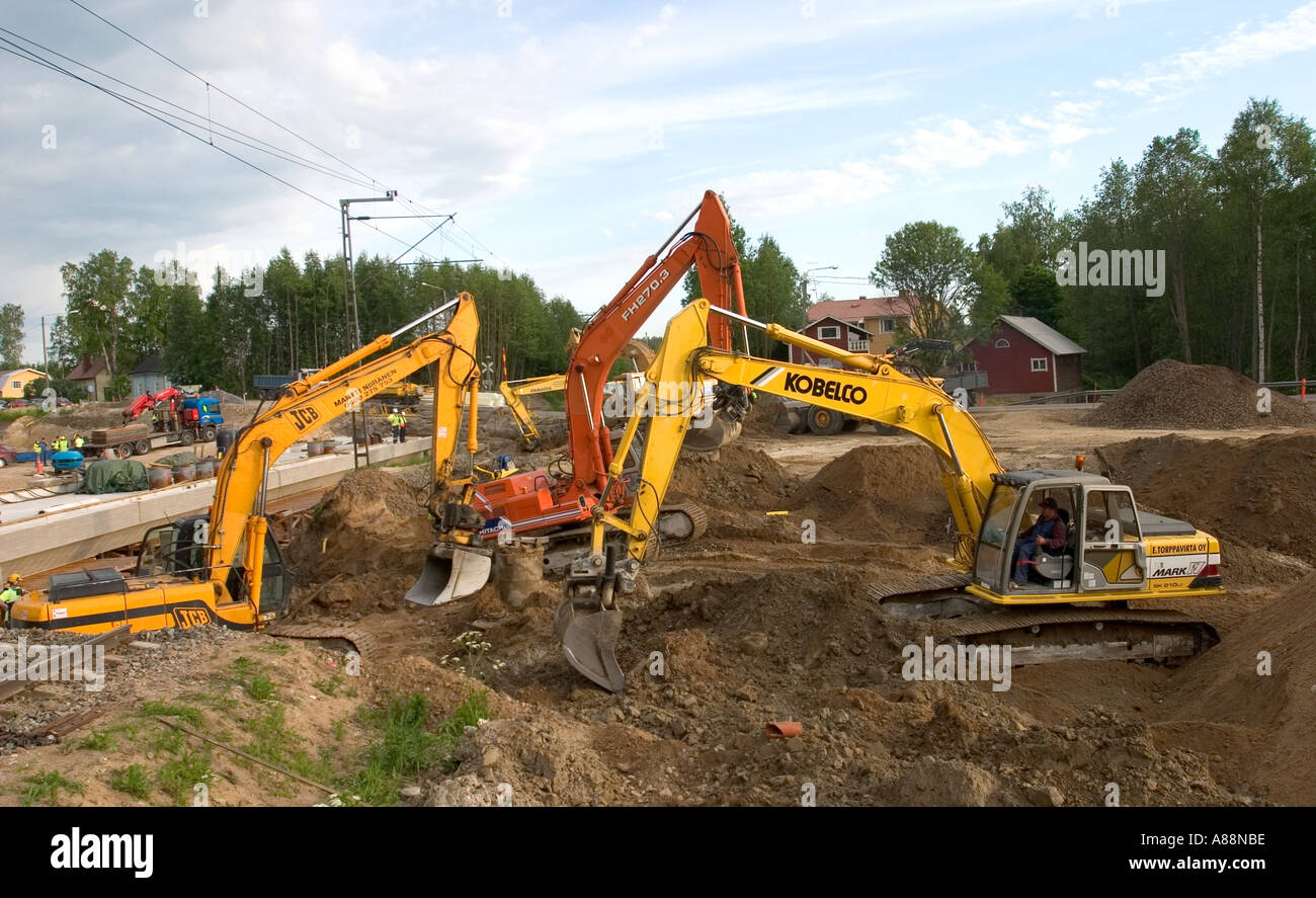 Diggers digging a pit for railroad bridge at evening light , Finland ...