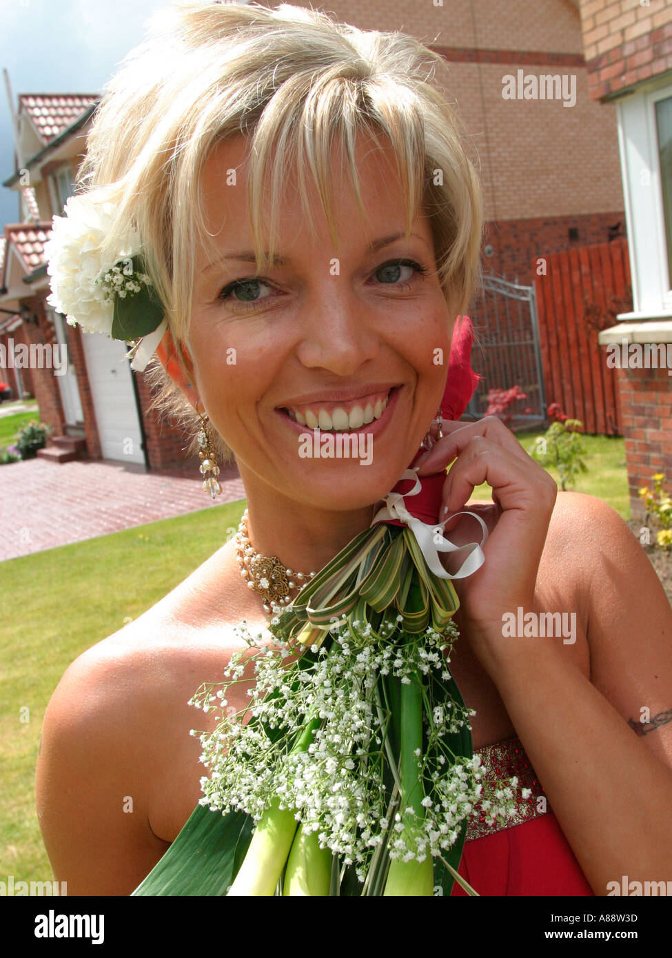 Blonde bride in cerisse dress holding canna flowers Stock Photo - Alamy