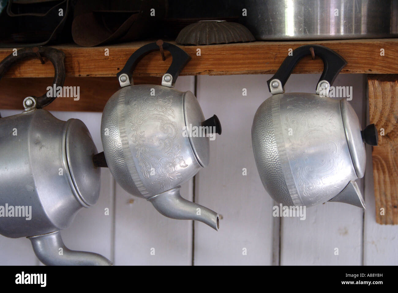A ROW OF TEAPOTS HANGING ON A WALL BDA10472 HORIZONTAL Stock Photo - Alamy