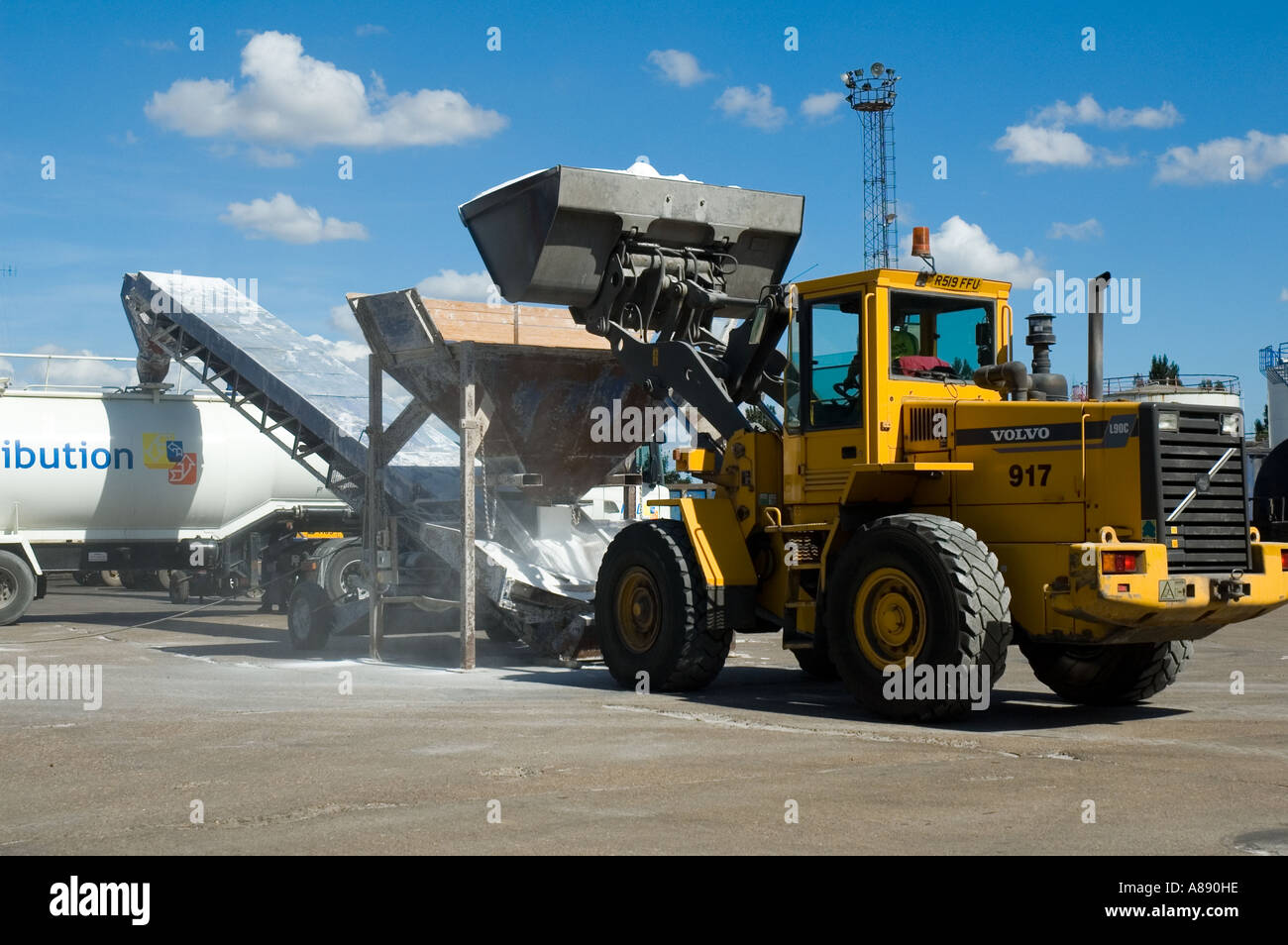 Volvo wheeled loader using a hopper and conveyor belt to load powdered ...