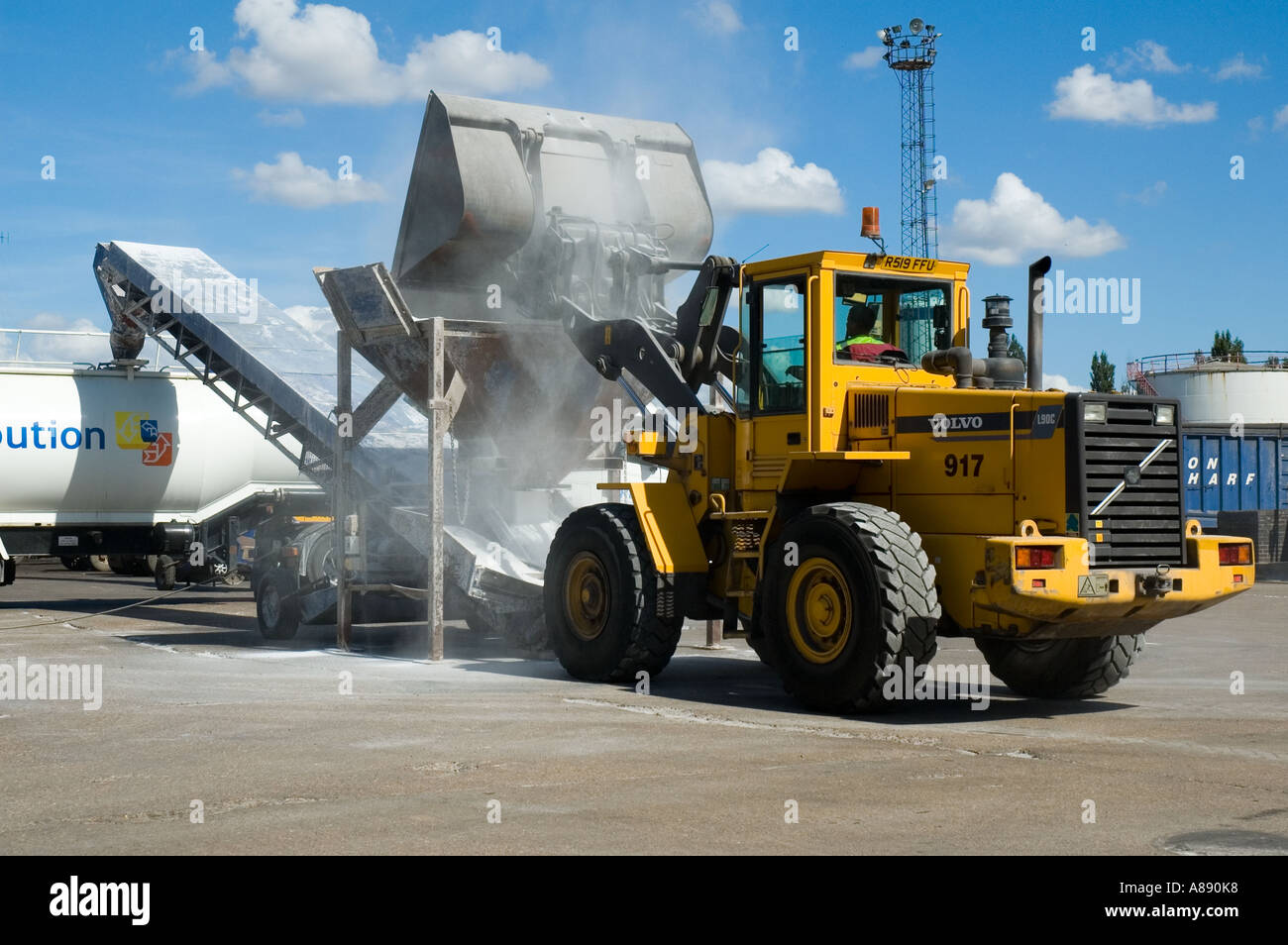 Volvo wheeled loader using a hopper and conveyor belt to load powdered ...