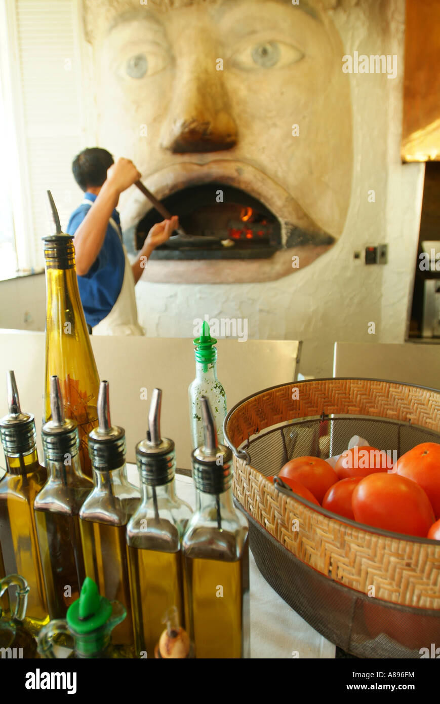 Margaro Castillo prepares and bakes pizzas in a wood burning oven at ...