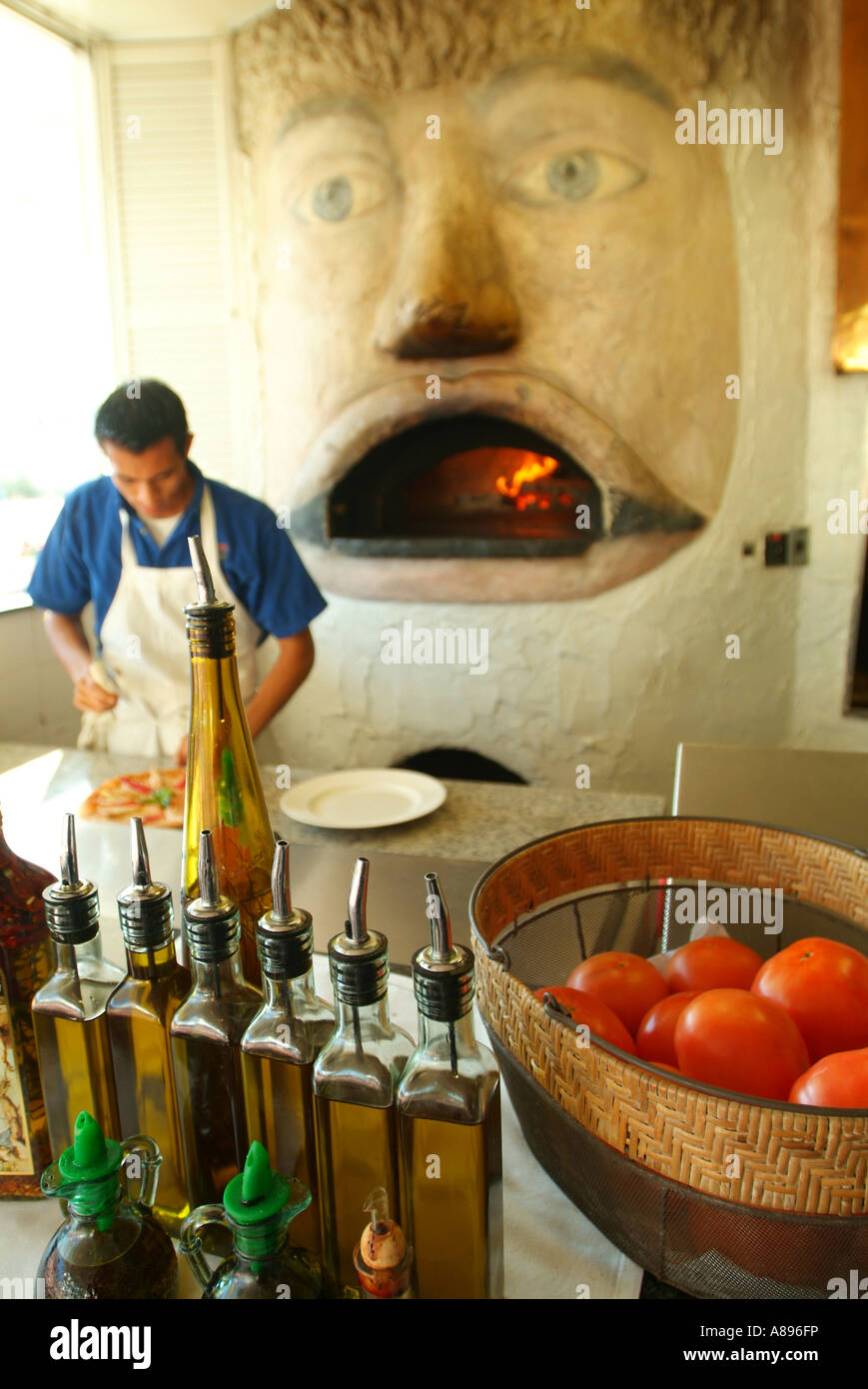 Margaro Castillo prepares and bakes pizzas in a wood burning oven at ...