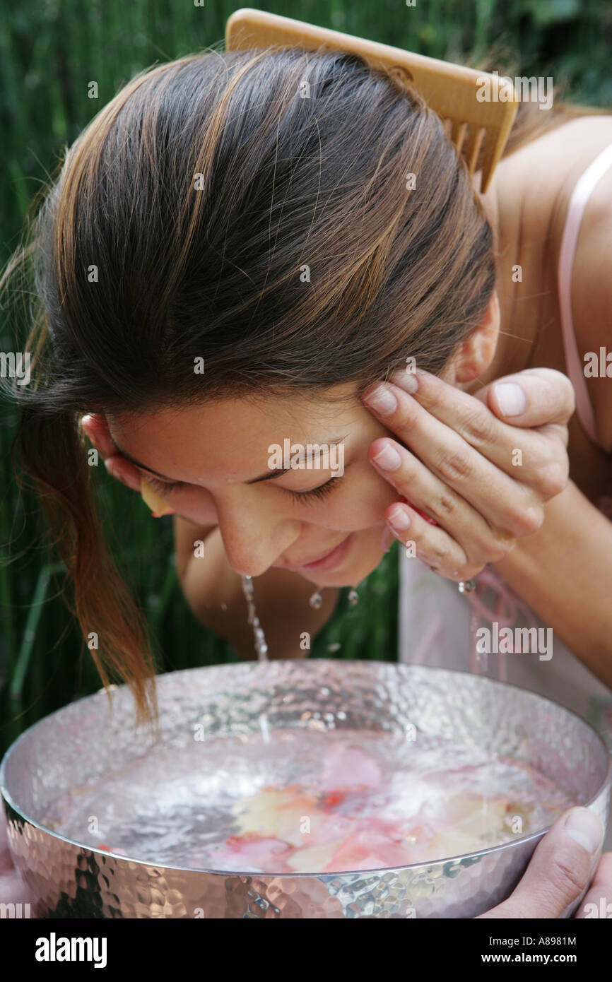 Woman washing her face over a metal bowl Stock Photo - Alamy