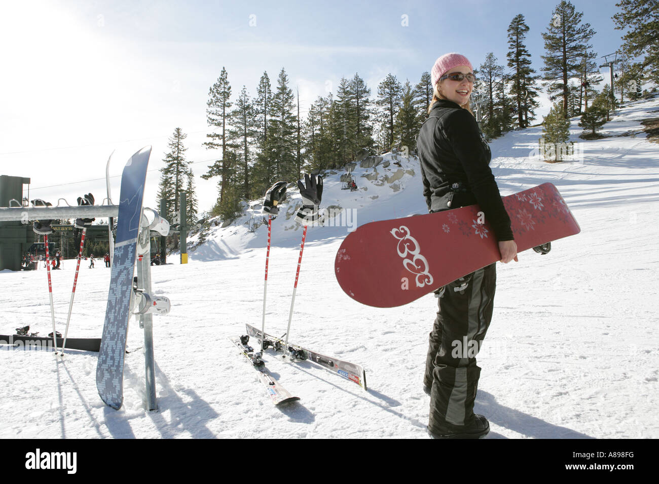 Woman with pink snowboard smiling at camera Stock Photo - Alamy