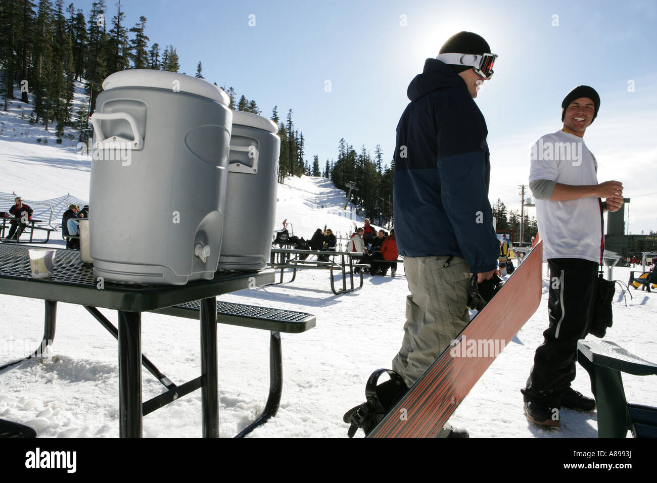 Two men in front of a table with coolers Stock Photo - Alamy