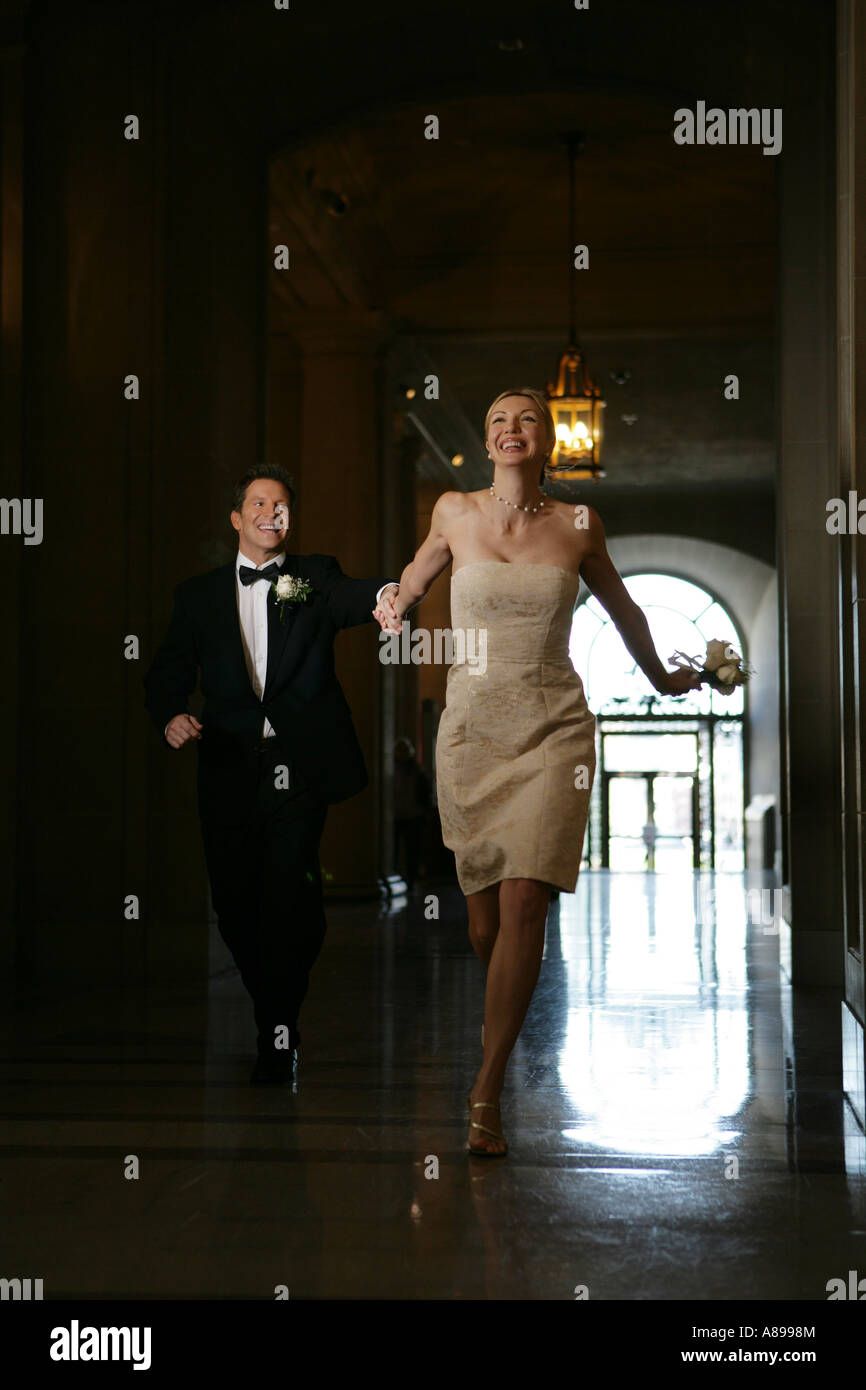 Couple running down a corridor Stock Photo - Alamy