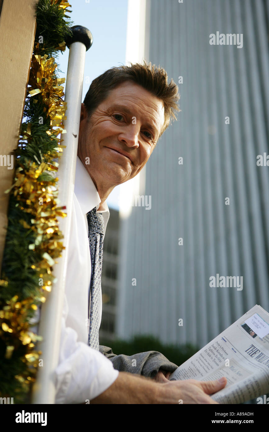 Mature man looking at camera holding a newspaper Stock Photo - Alamy