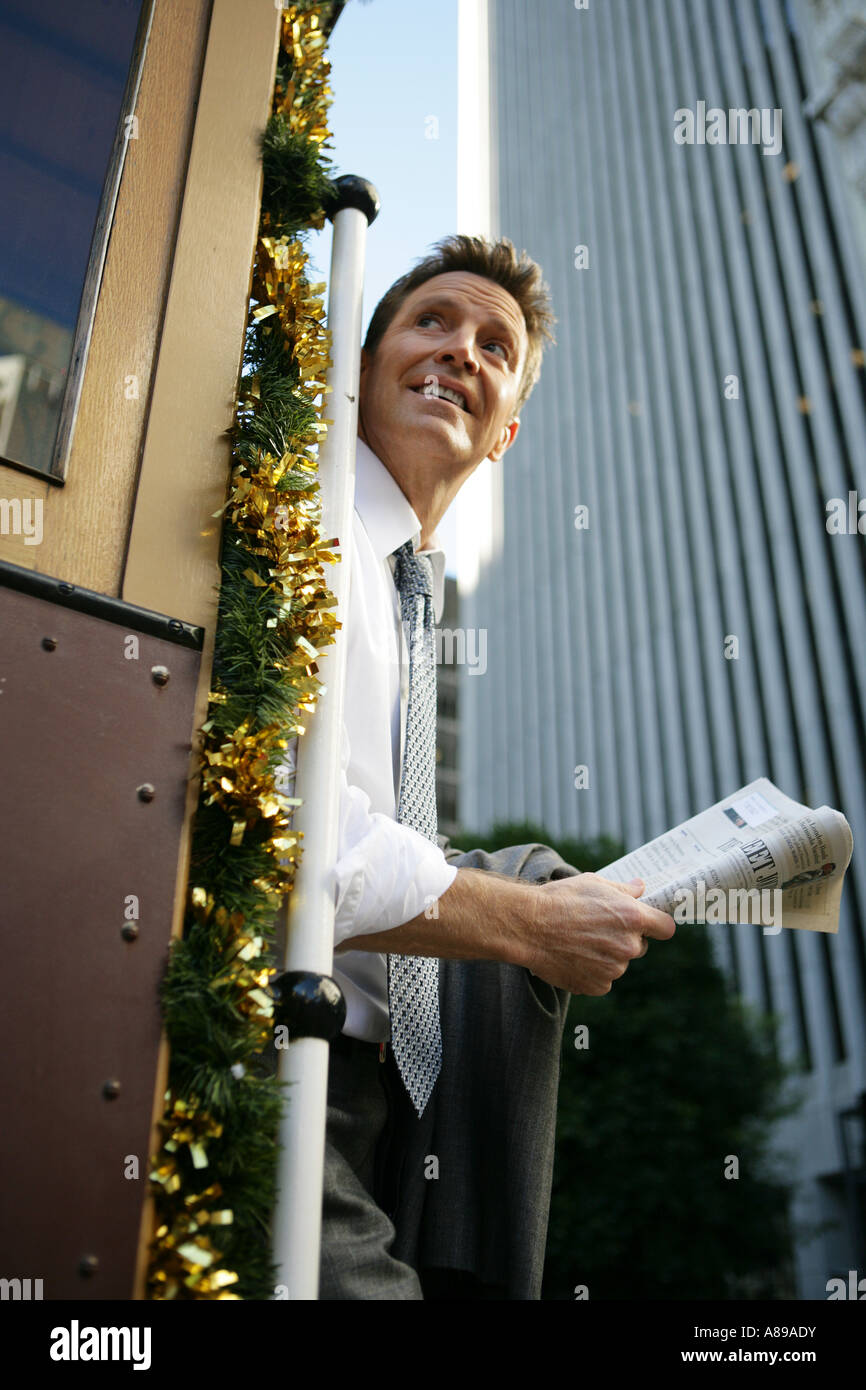 Mature man riding a trolley with newspaper Stock Photo - Alamy