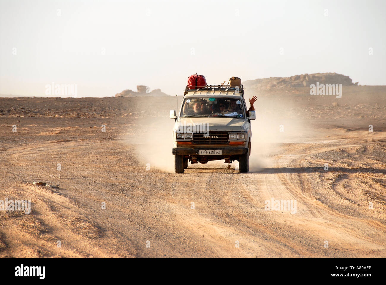 Landcruiser drives on dusty road through the desert Acacus Libya Stock ...