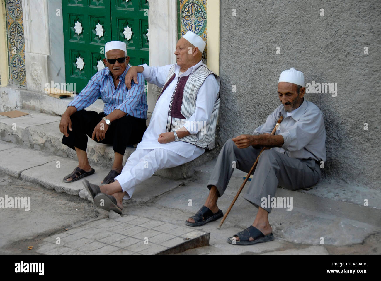 Three believers sit in front of Gurgi mosque medina Tripolis Libya ...