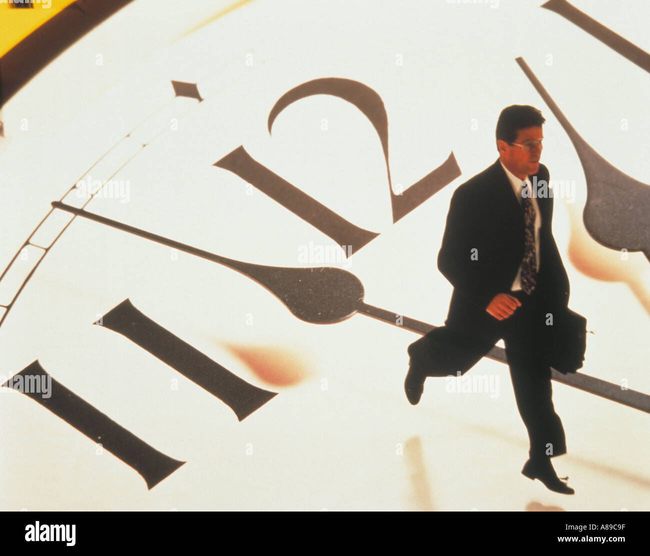 Businessman walking on clock face Stock Photo - Alamy