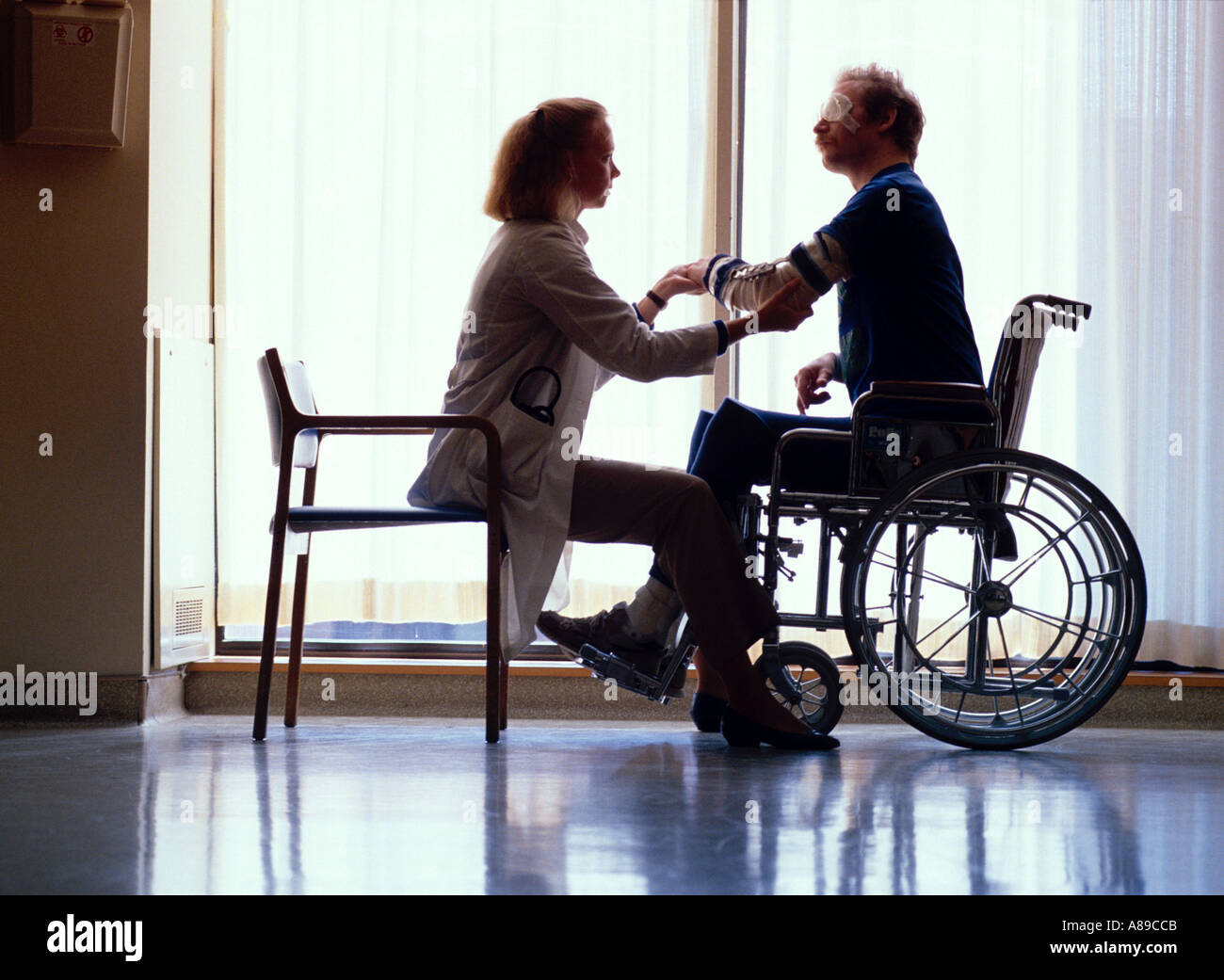 A partially paralyzed patient sits in a wheelchair by the window as the ...