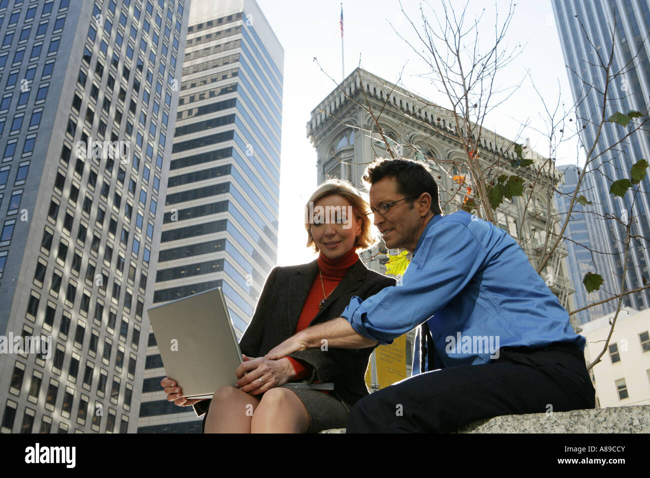Two people looking at a laptop Stock Photo - Alamy