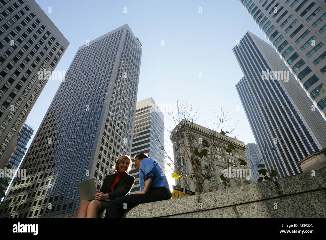 Two people talking outside with a laptop Stock Photo - Alamy