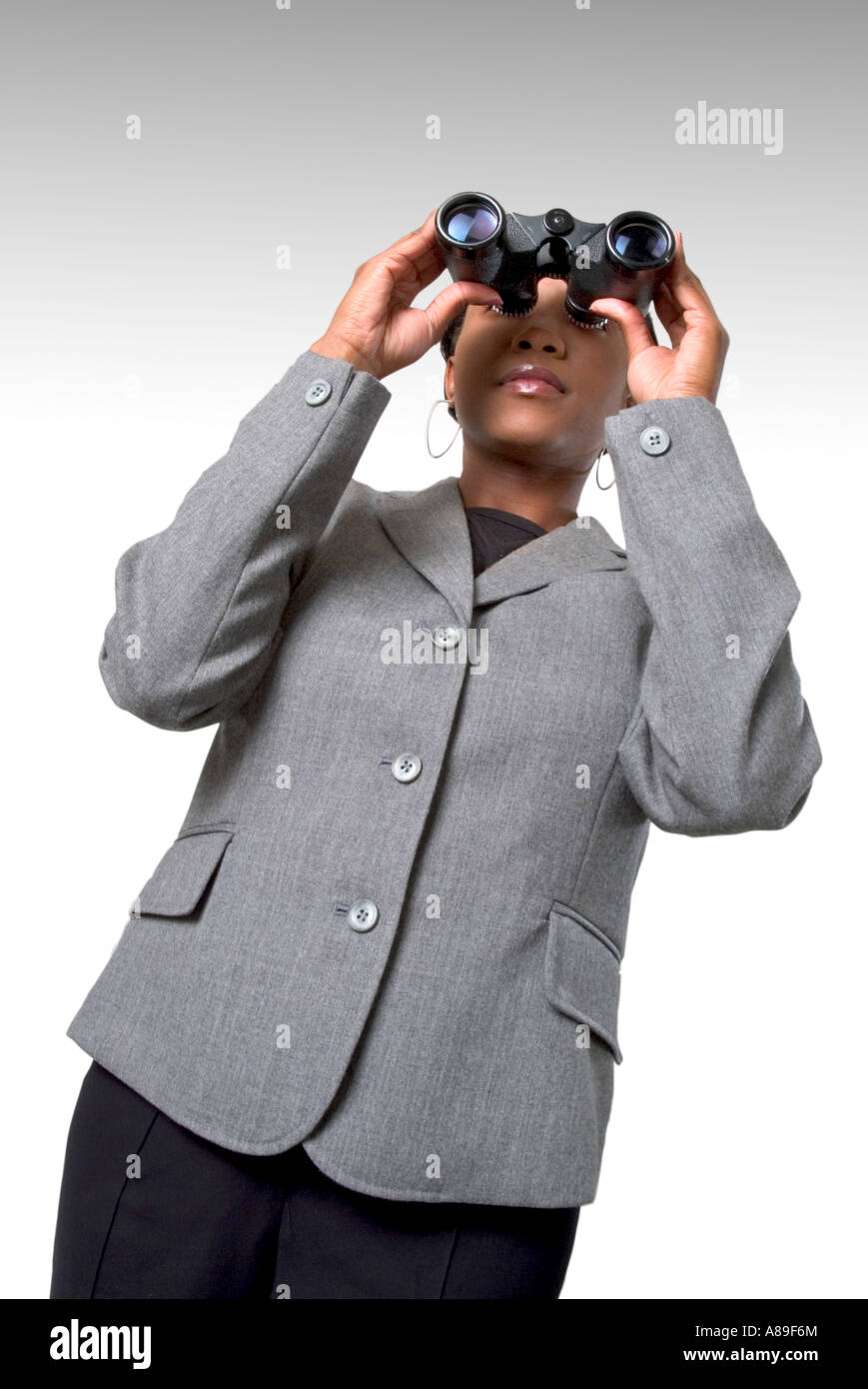 Young ethnic black woman looking through binoculars depicting a person ...