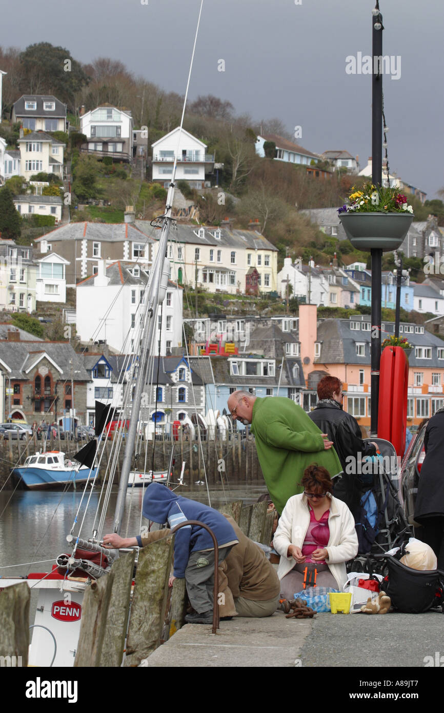 Looe Cornwall family crab fishing at West Looe harbour Stock Photo - Alamy