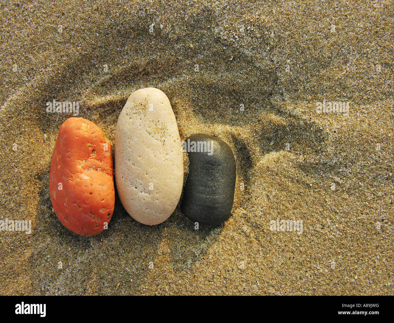Colored pebbles in the sand Stock Photo - Alamy
