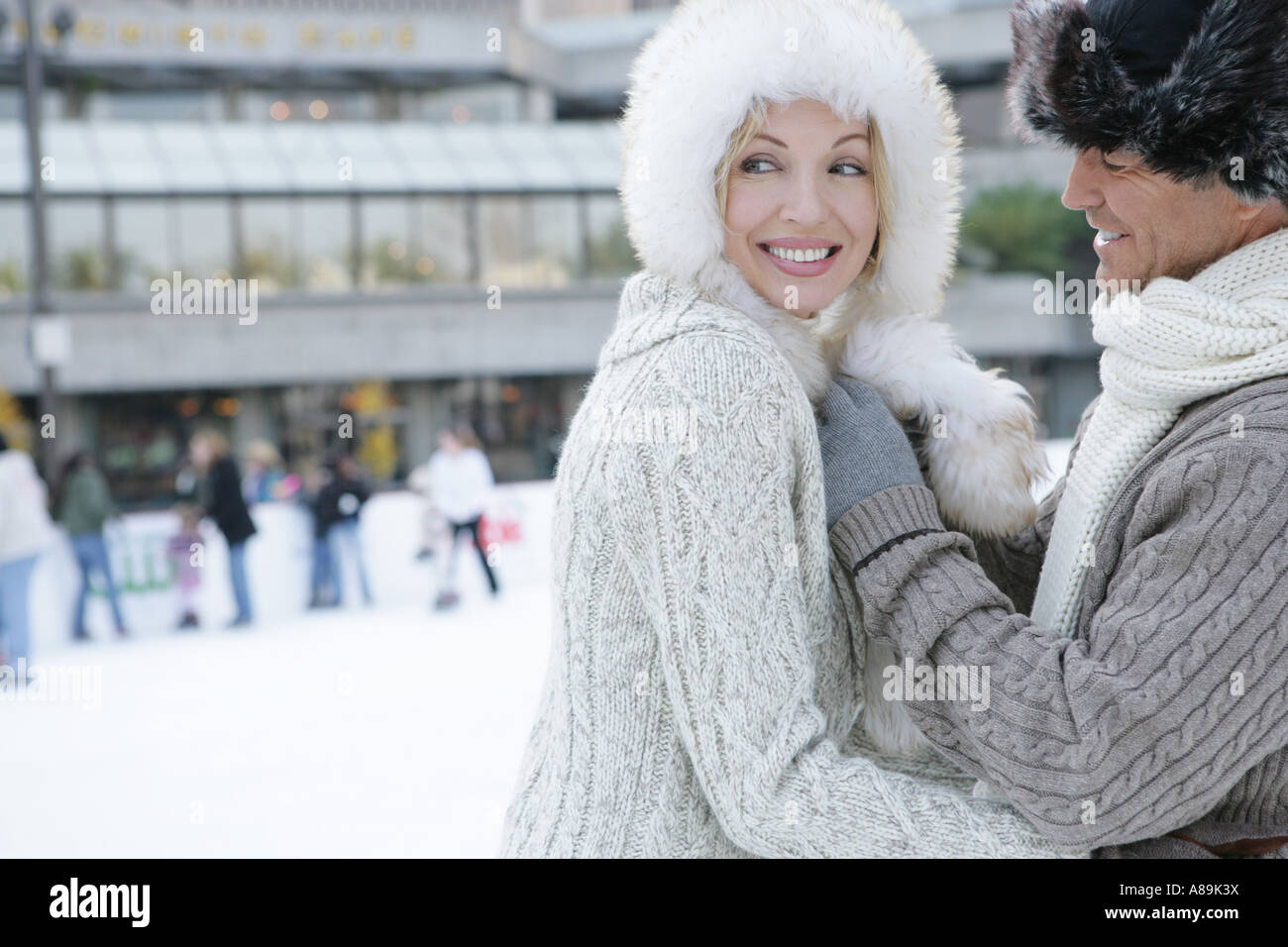 Man fixing a womans hat Stock Photo - Alamy