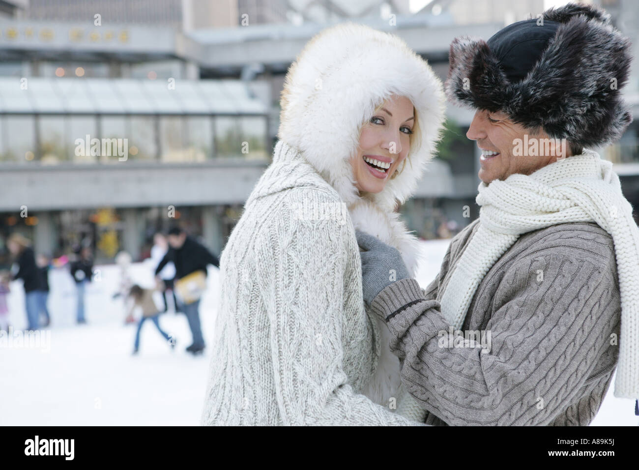 Man fixing a woman's hat Stock Photo - Alamy
