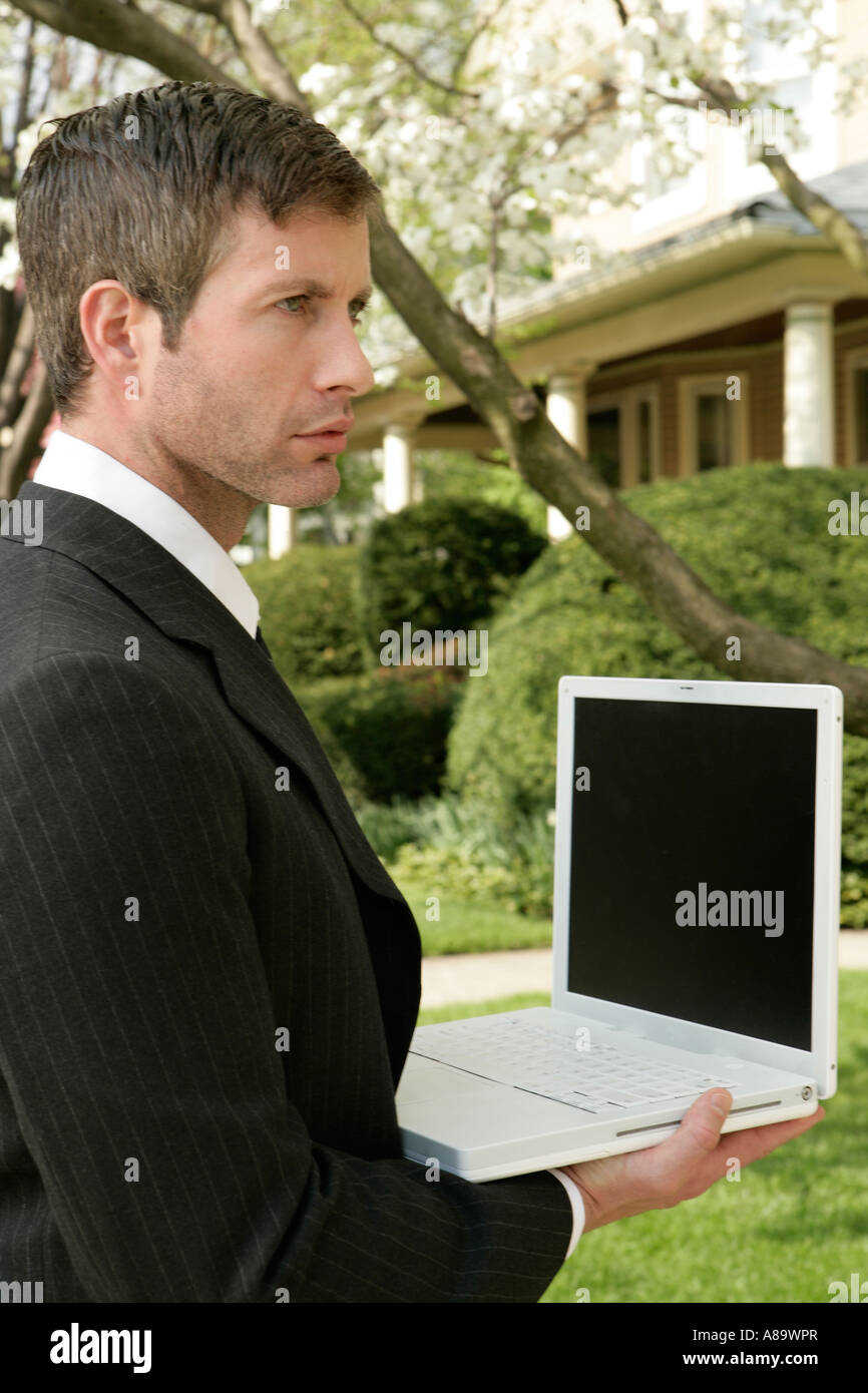 Business man holding laptop outside Stock Photo - Alamy