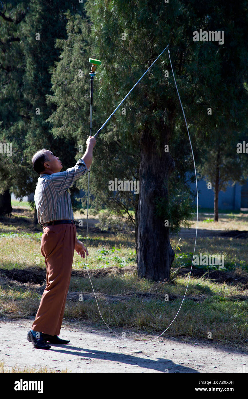 CHINA BEIJING Elderly Chinese man having fun whirling and balancing a ...