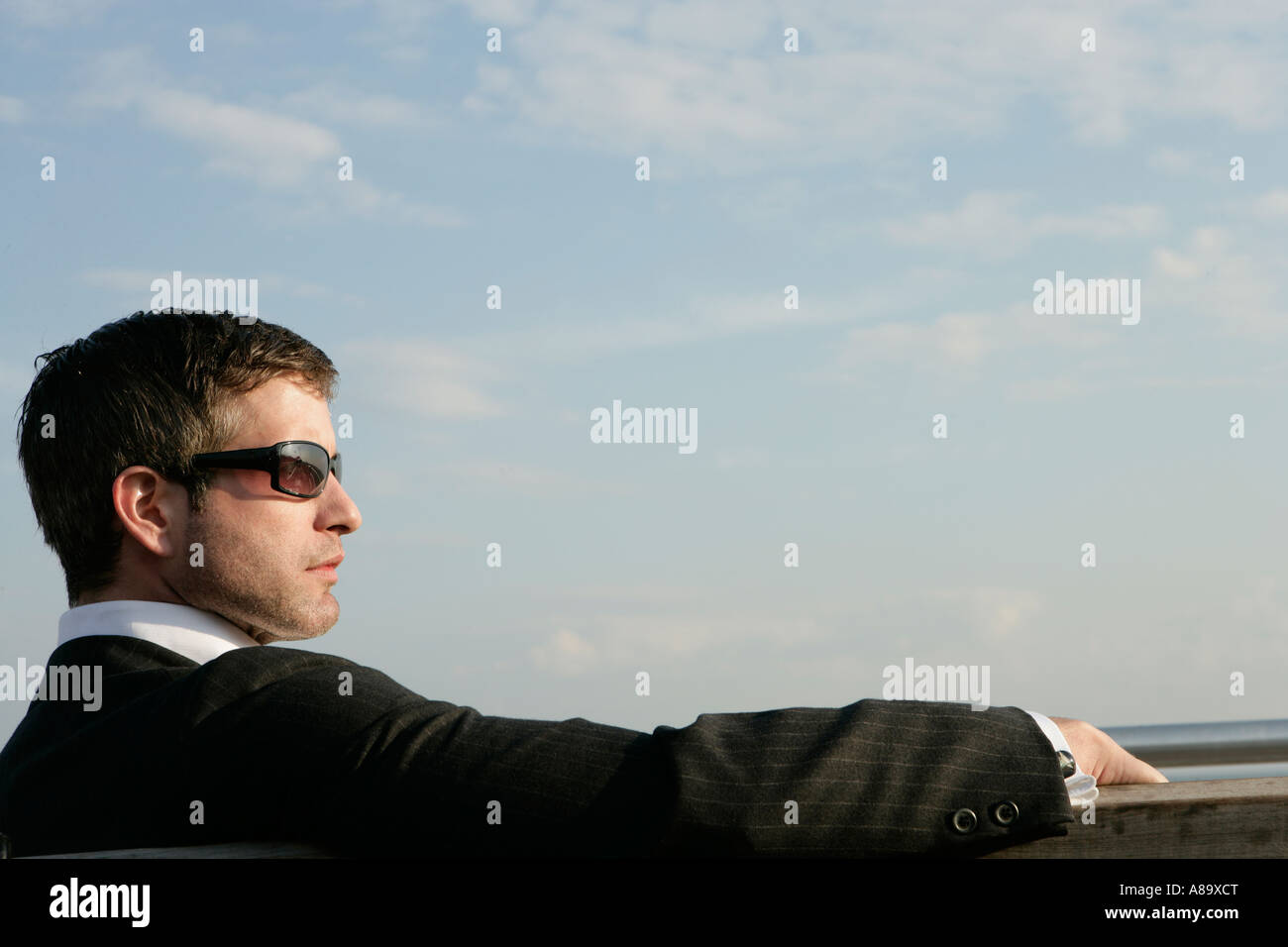 Man sitting with his arm extended Stock Photo - Alamy