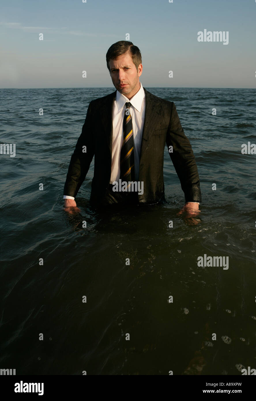 Man in a suit standing waist high in water Stock Photo - Alamy