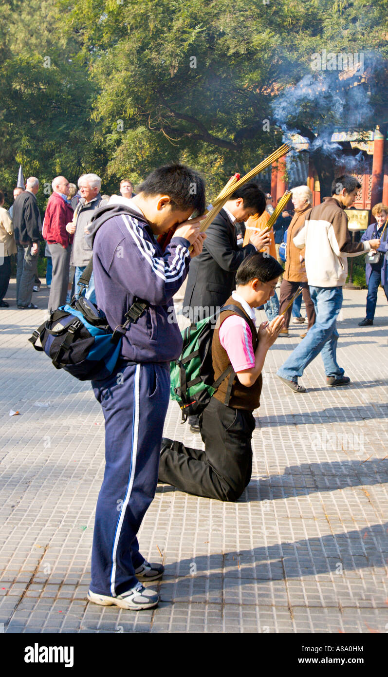 CHINA BEIJING Chinese Buddhists burn incense and kneel to pray outside ...