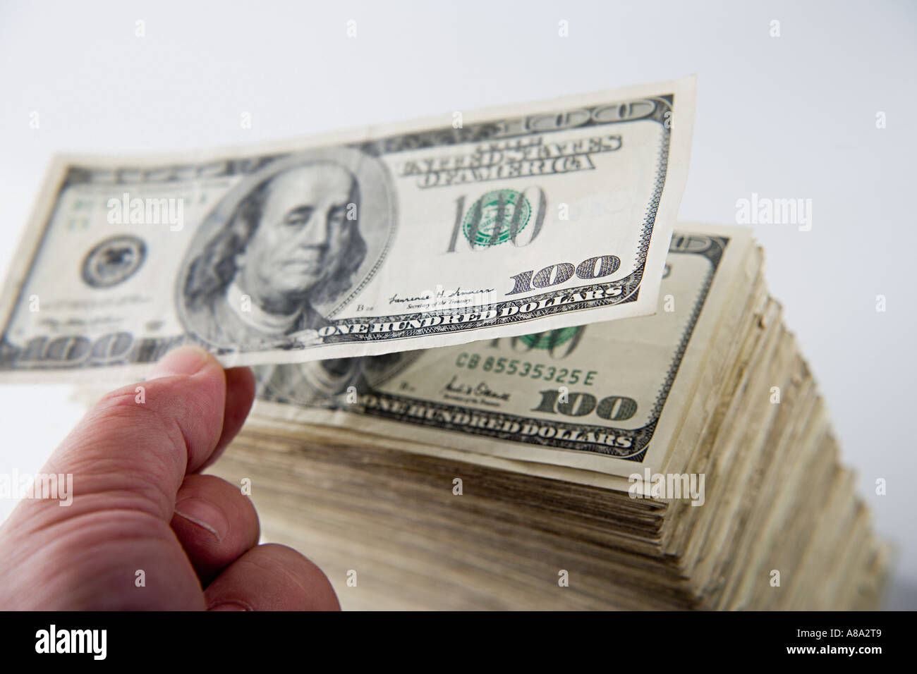 Person stacking hundred dollar bills Stock Photo - Alamy