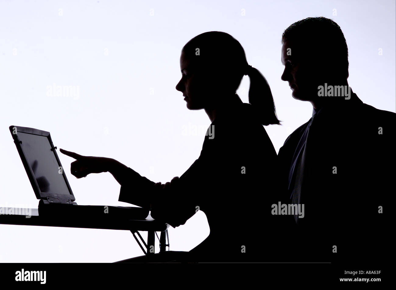Silhouette of man and woman working at computer workstation Stock Photo ...