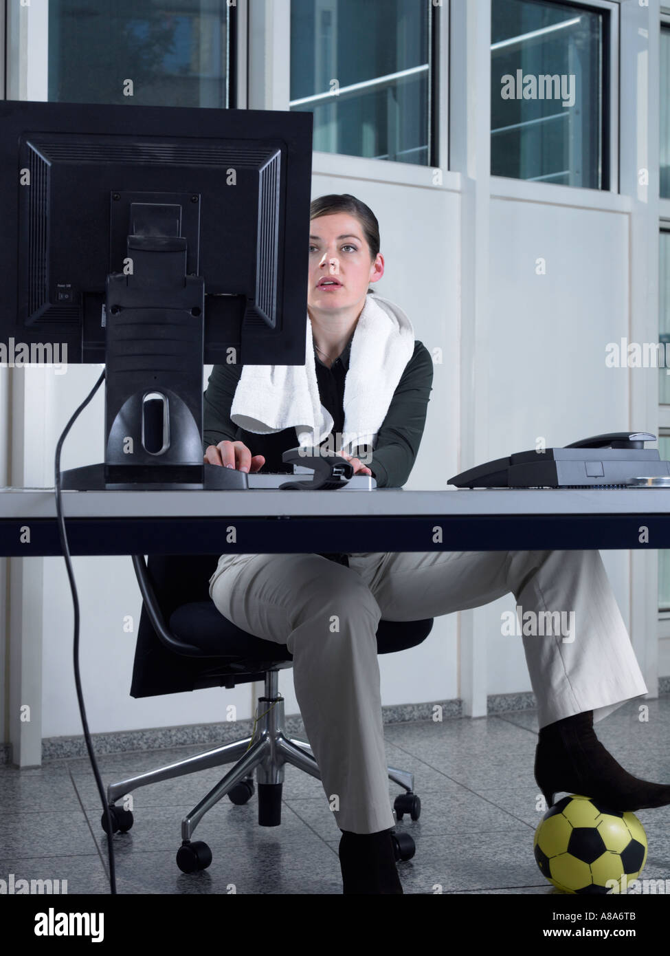 Woman with football under desk Stock Photo - Alamy