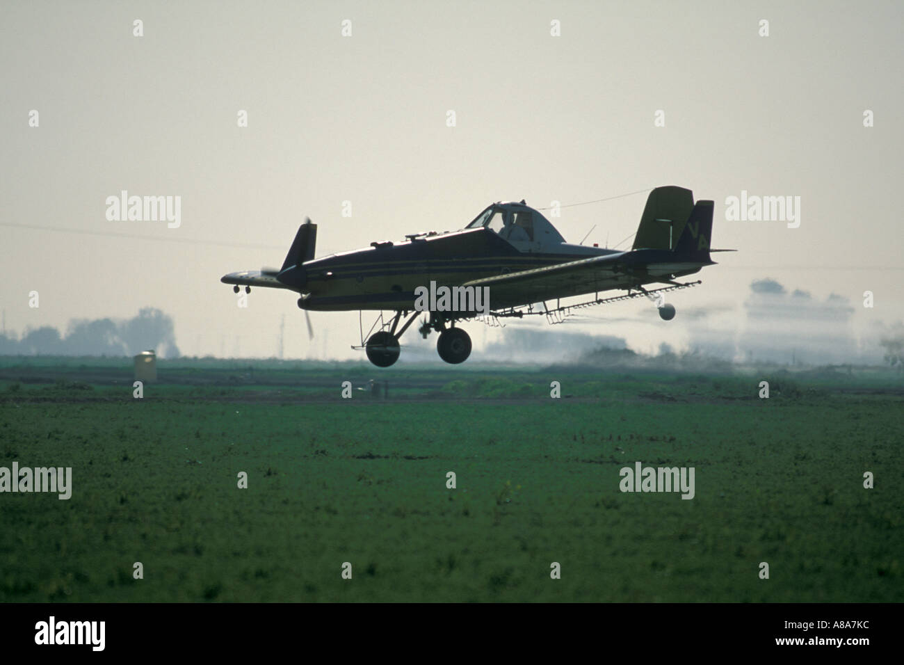 Piper PA 25 Pawnee airplane crop dusting over agricultural farmlands ...