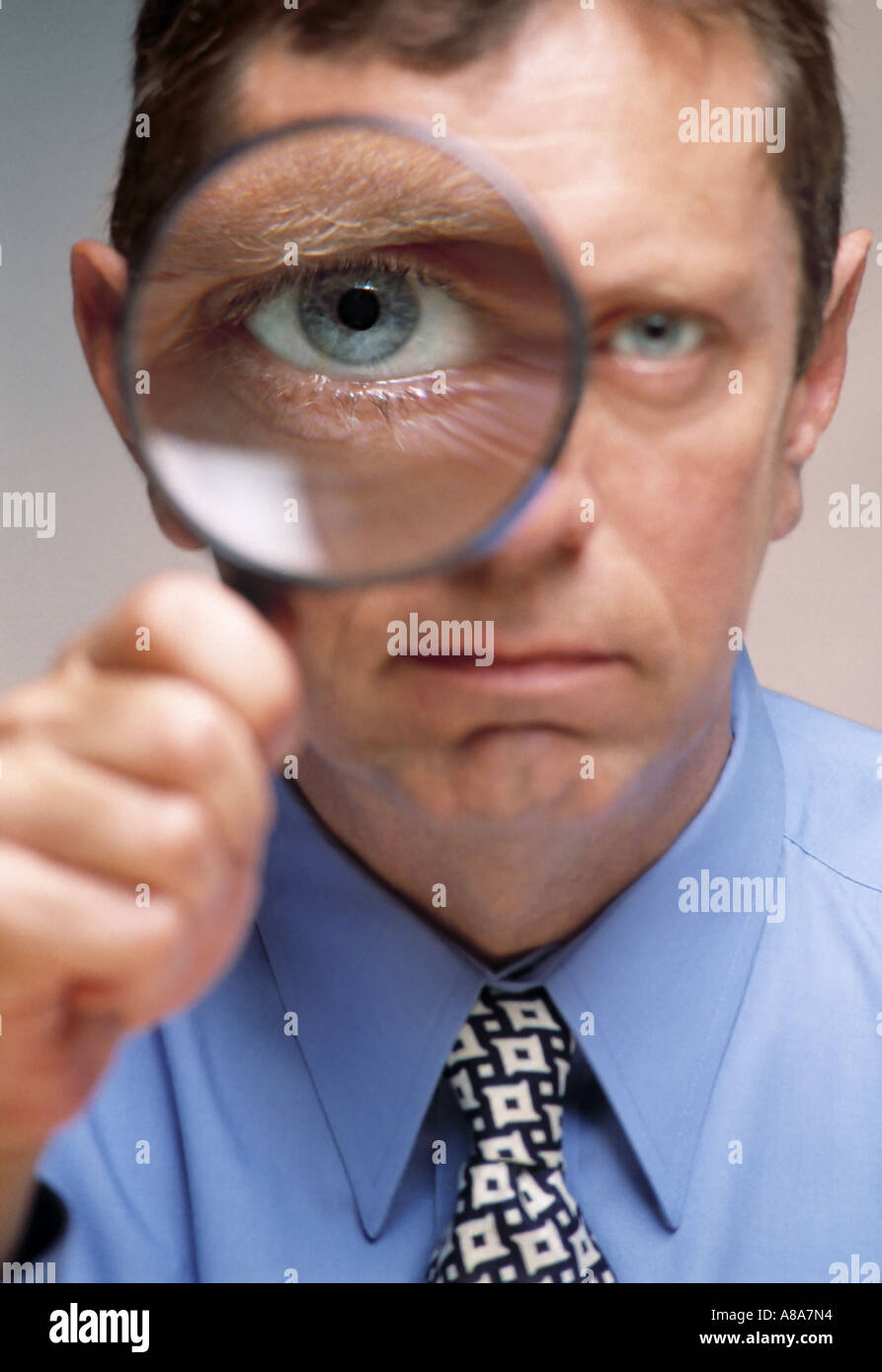 Man holding a magnifying glass Stock Photo - Alamy