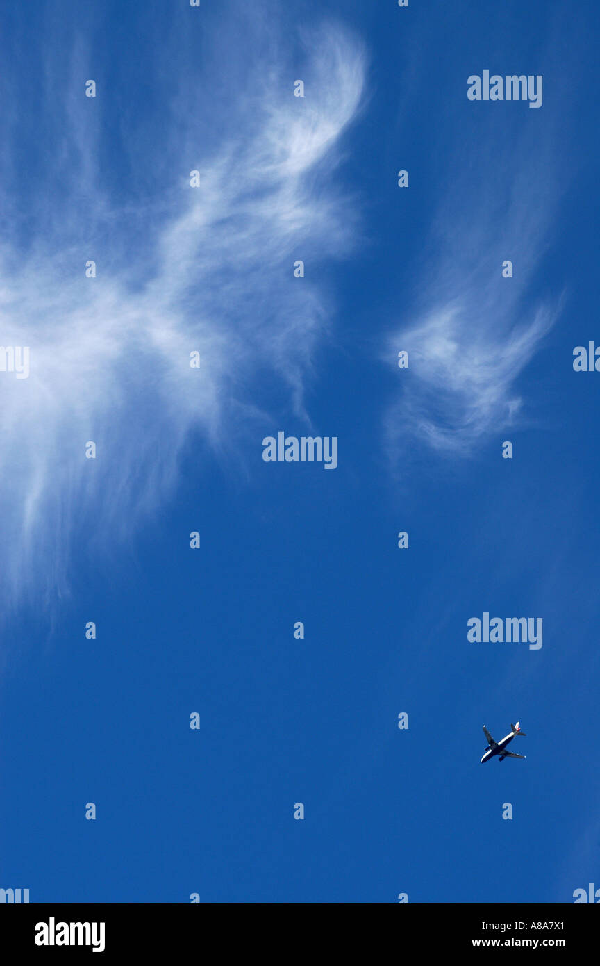 Plane flying across blue skies Stock Photo - Alamy